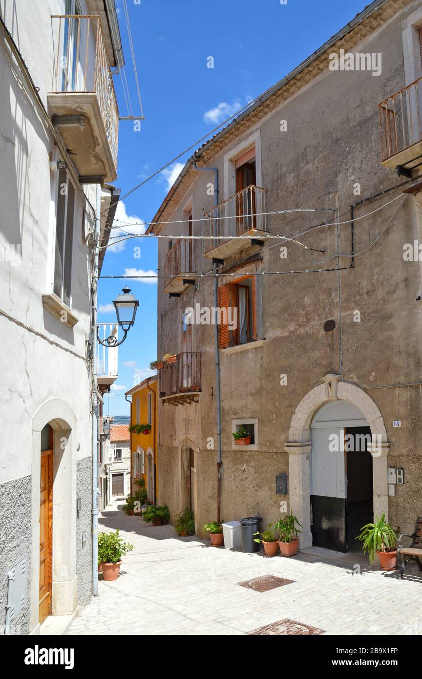 A narrow street between the old houses of Sepino, a medieval village in ...