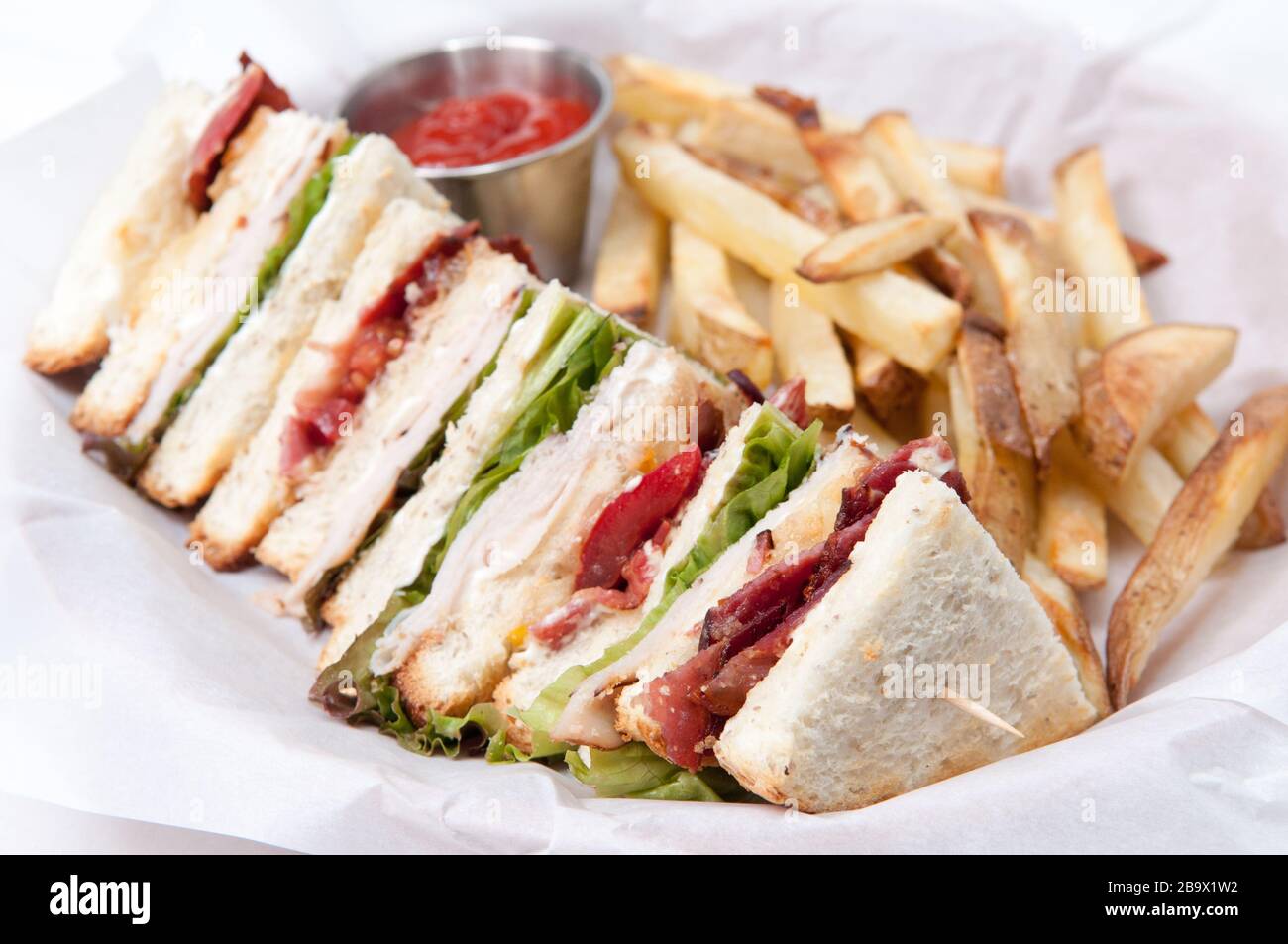 A clubhouse sandwich with fries Stock Photo - Alamy