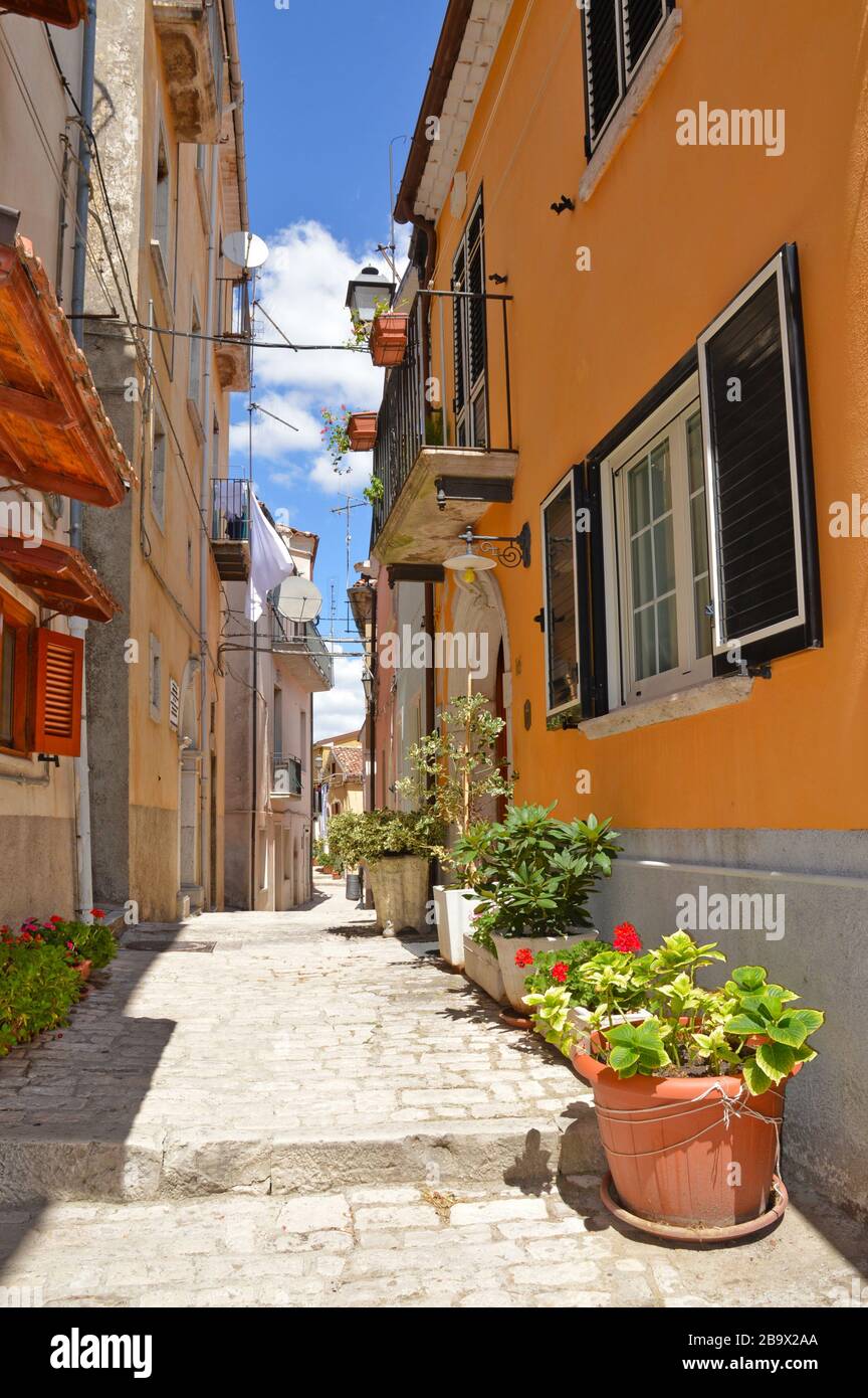 A narrow street between the old houses of Sepino, a medieval village in ...