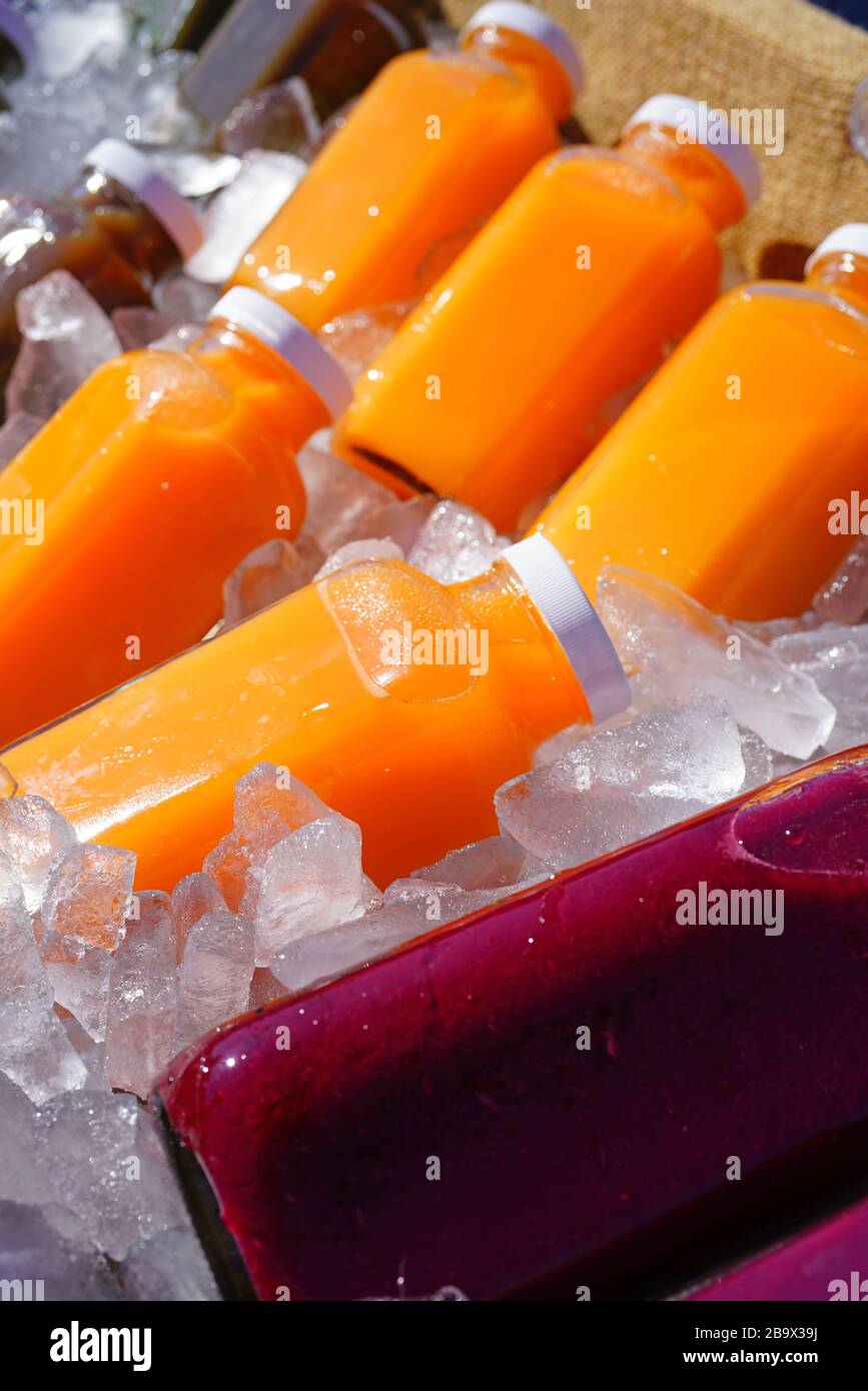 Bottles of colorful cold pressed juice on ice Stock Photo - Alamy