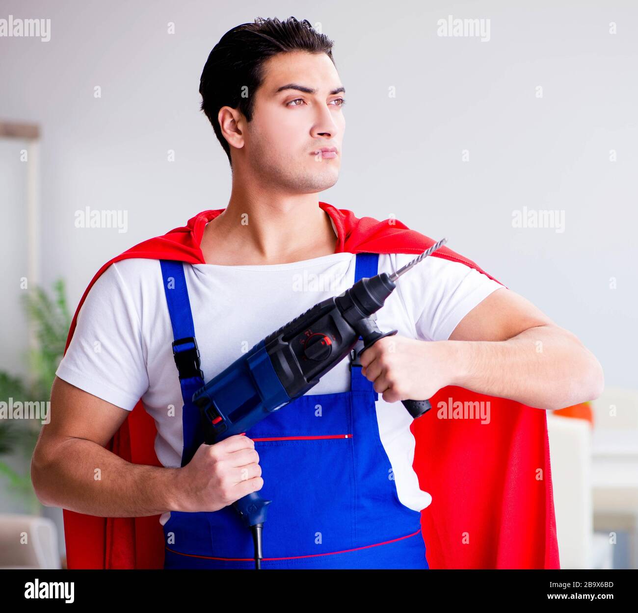 The superhero repairman with tools in repair concept Stock Photo - Alamy