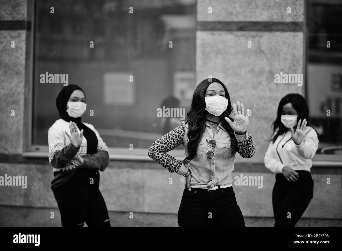 Group of three african american young volunteers wearing face mask ...