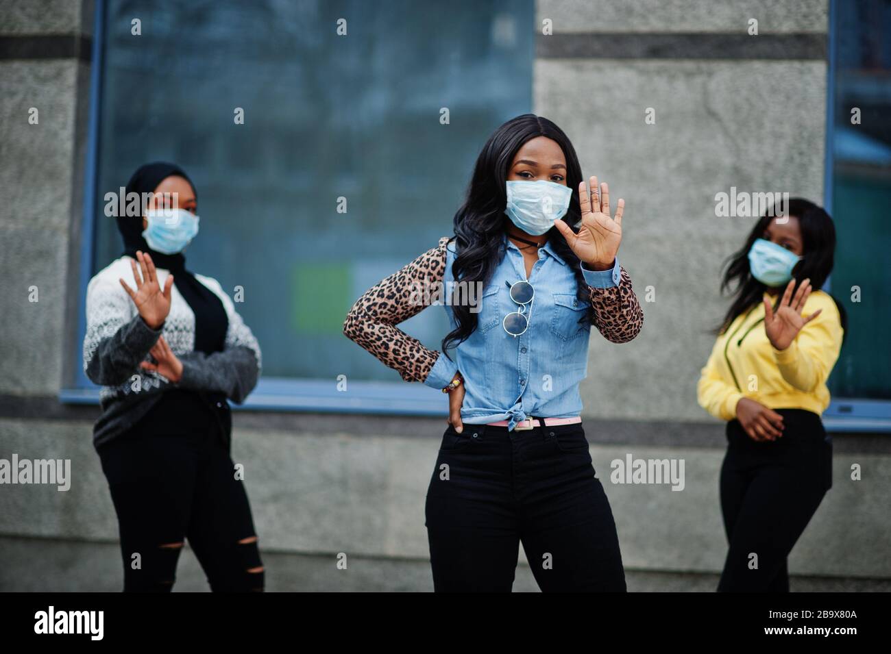 Group of three african american young volunteers wearing face mask ...
