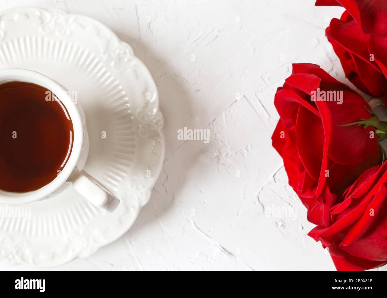 Cup of tea and red roses, top view, copy space Stock Photo - Alamy