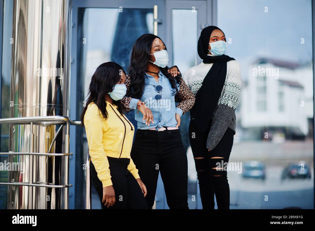 Group of three african american young volunteers wearing face mask ...