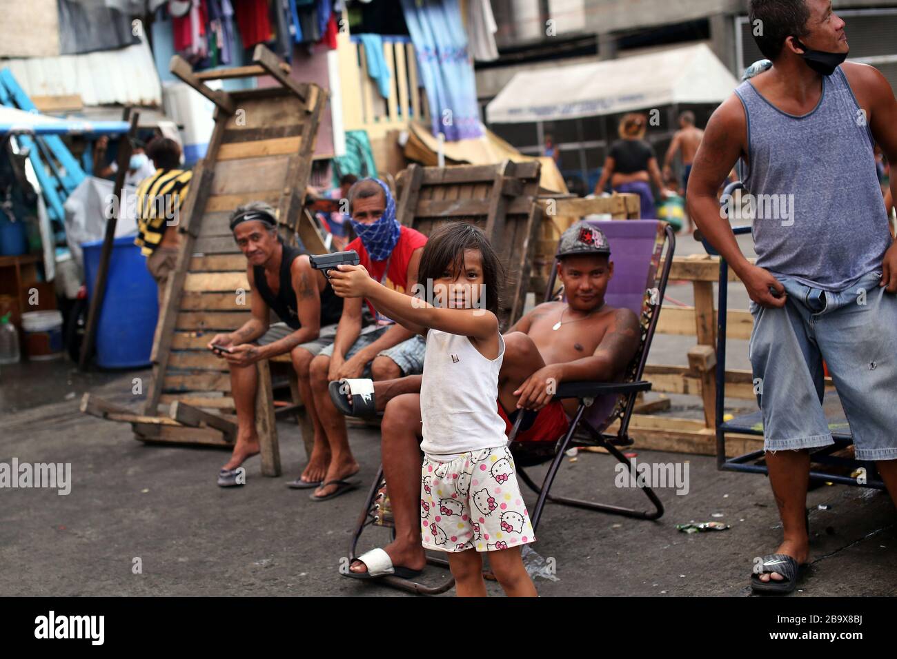 25 March 2020, Philippines, Manila: People sitting in a street in a ...