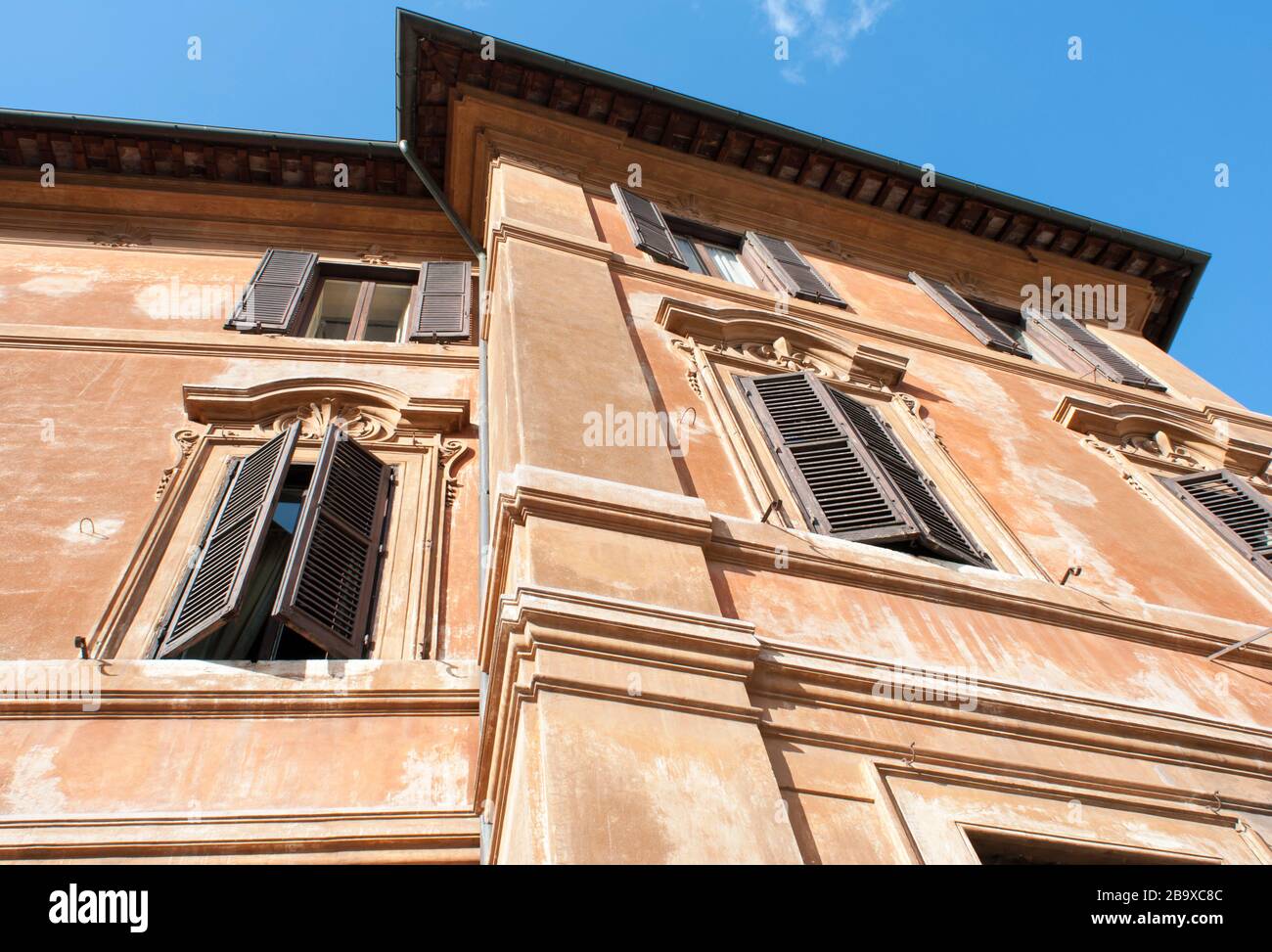 The orange color building with opened windows in Rome old town (Italy ...