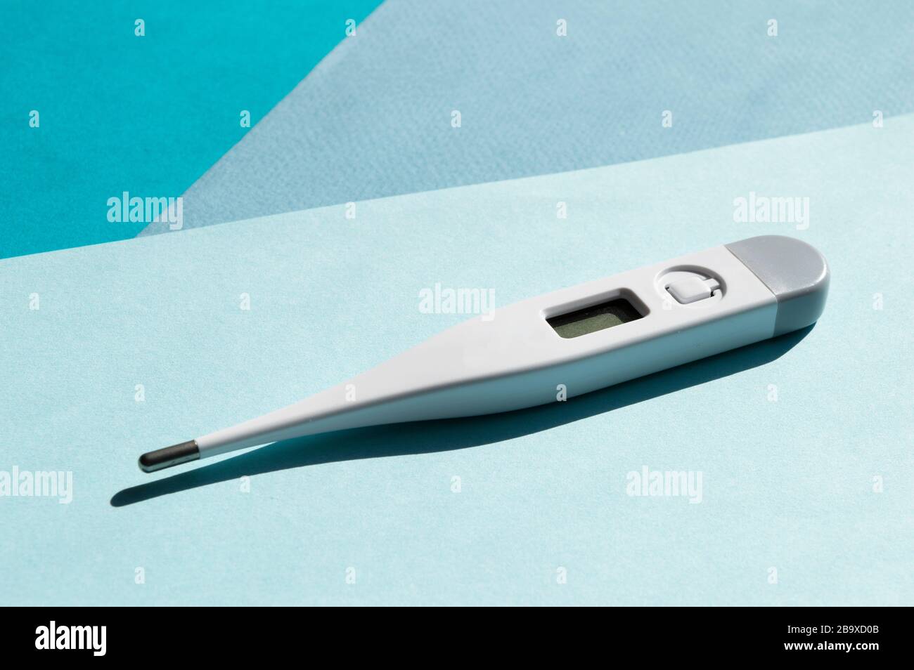 One plastic white electronic thermometer with shadows isolated on sunny ...