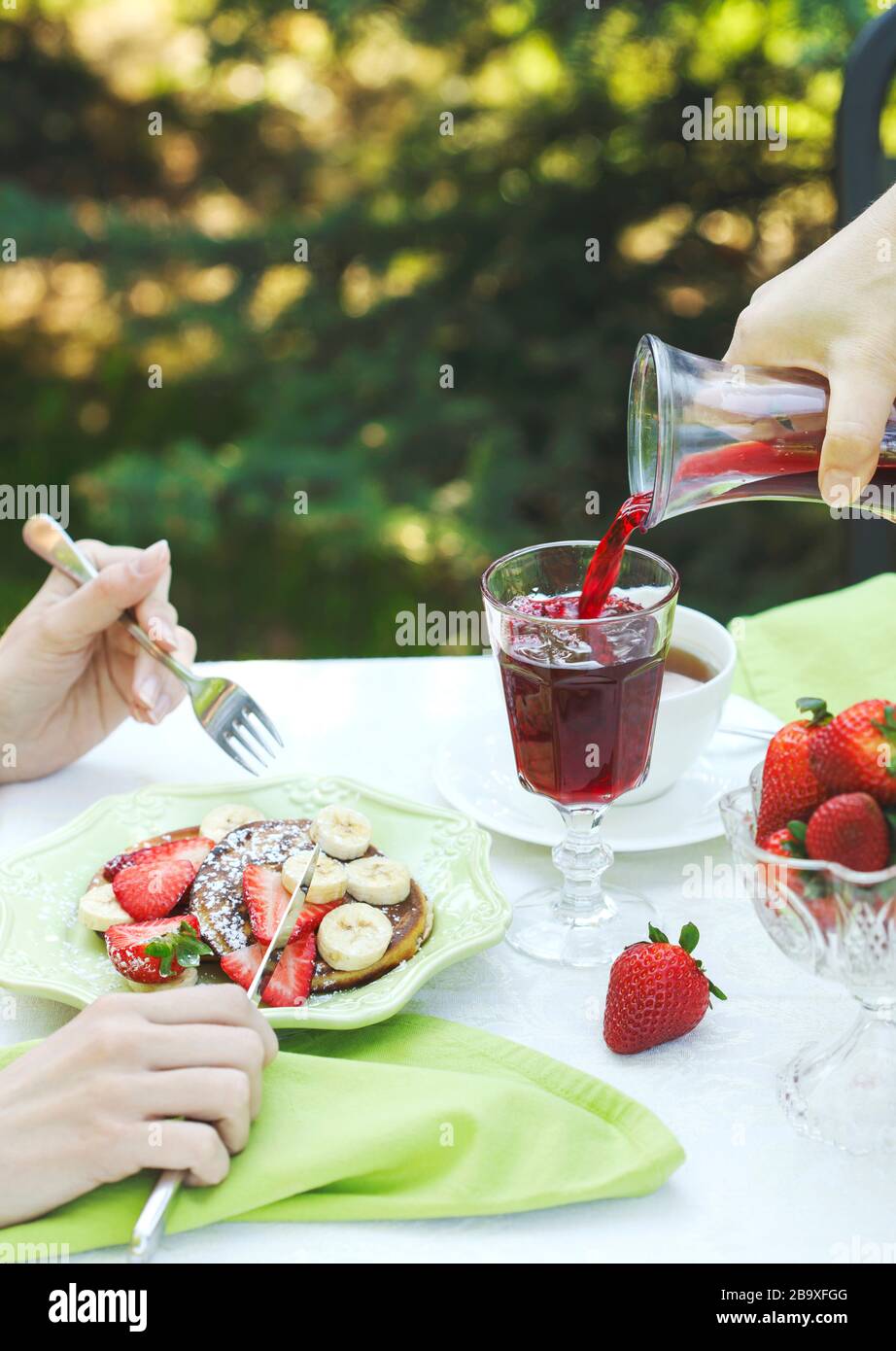 Summer breakfast in the garden. Pancakes with strawberry and banana ...