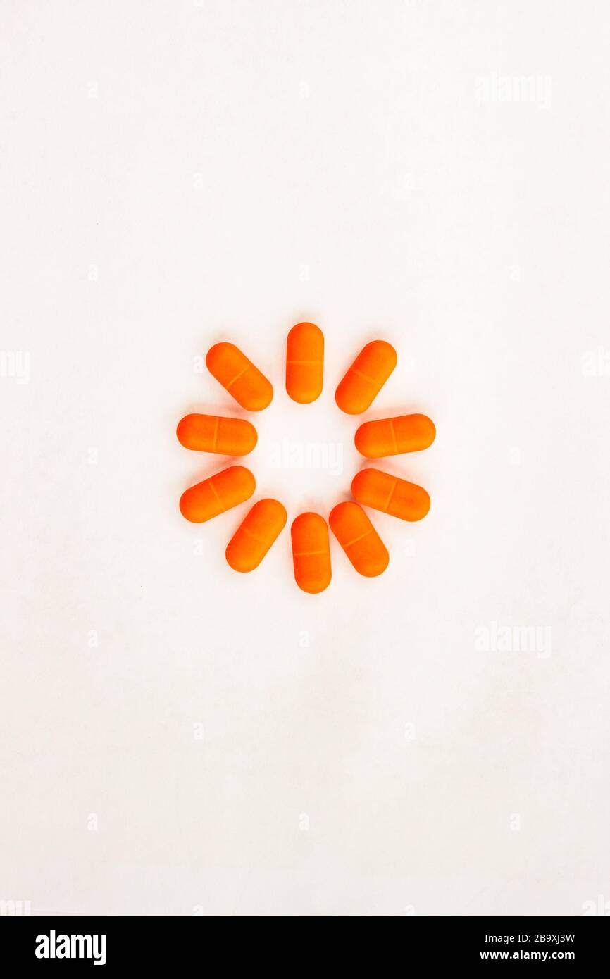 Sun made of orange pills on white background. childrens antipyretic ...