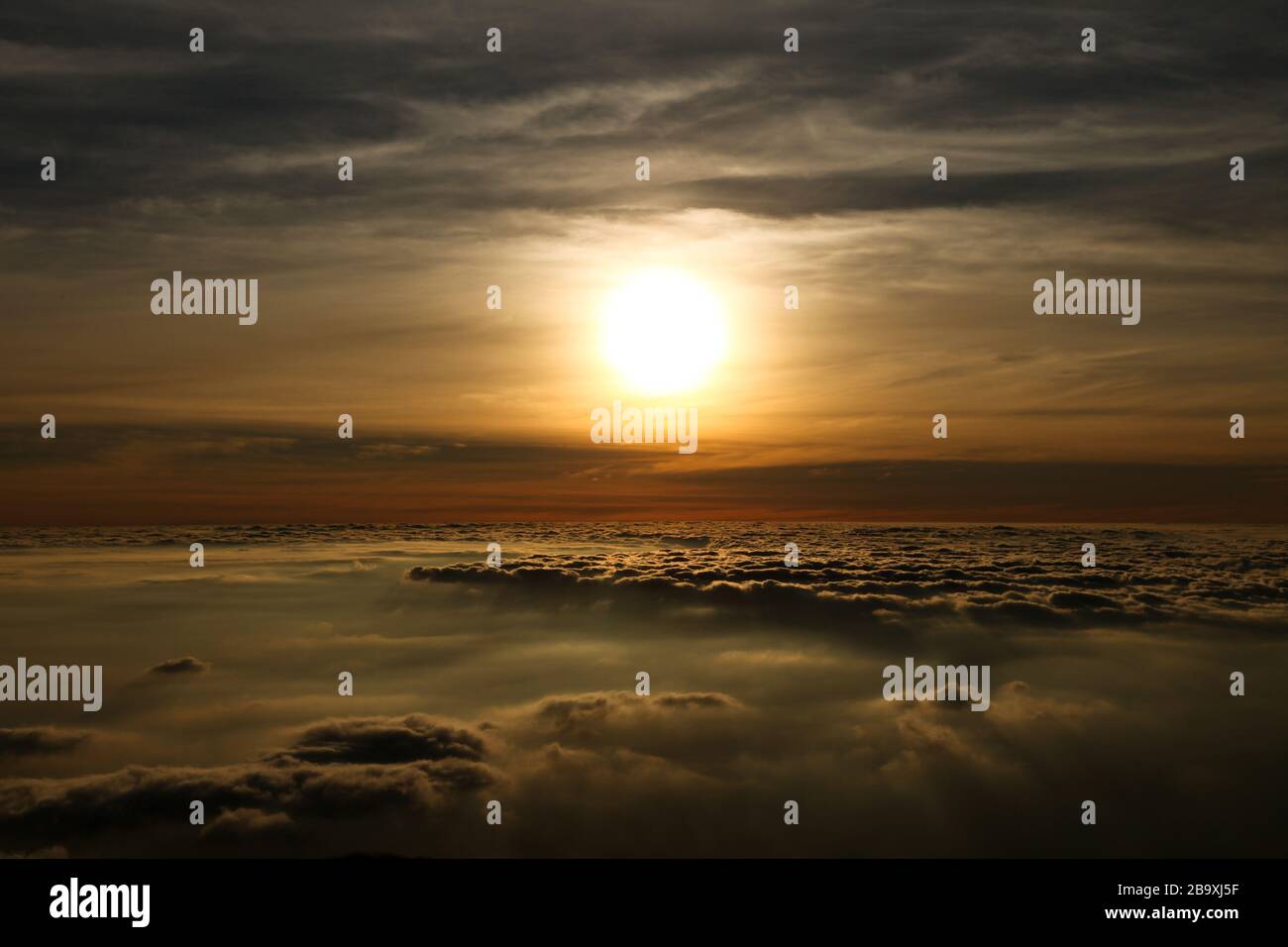Beautiful rising sun glowing over the clouds Stock Photo - Alamy