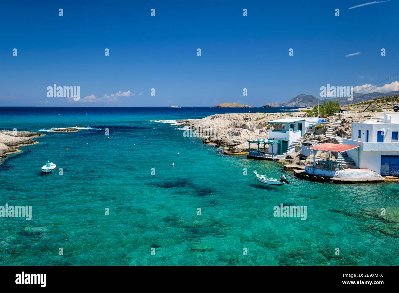 Small harbor with fishing boats in clear water, whitewashed house ...