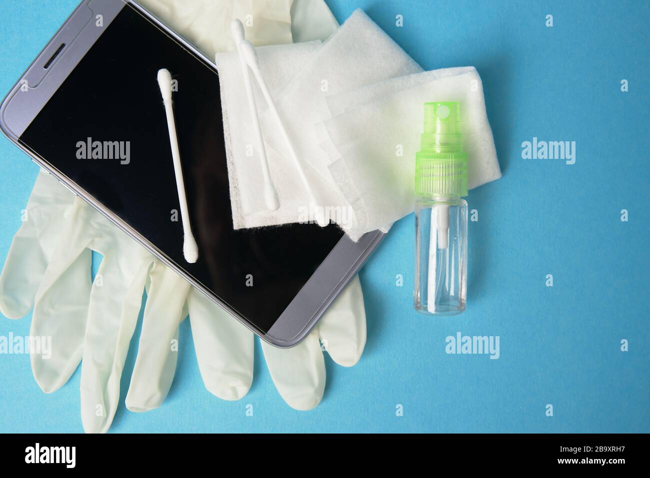 smartphone disinfection. sanitizer virus spray. blue background Stock ...