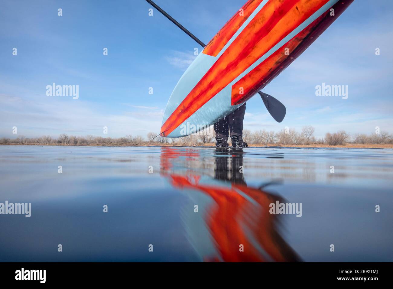 lifting a stand up paddleboard after paddling on a calm lake in ...
