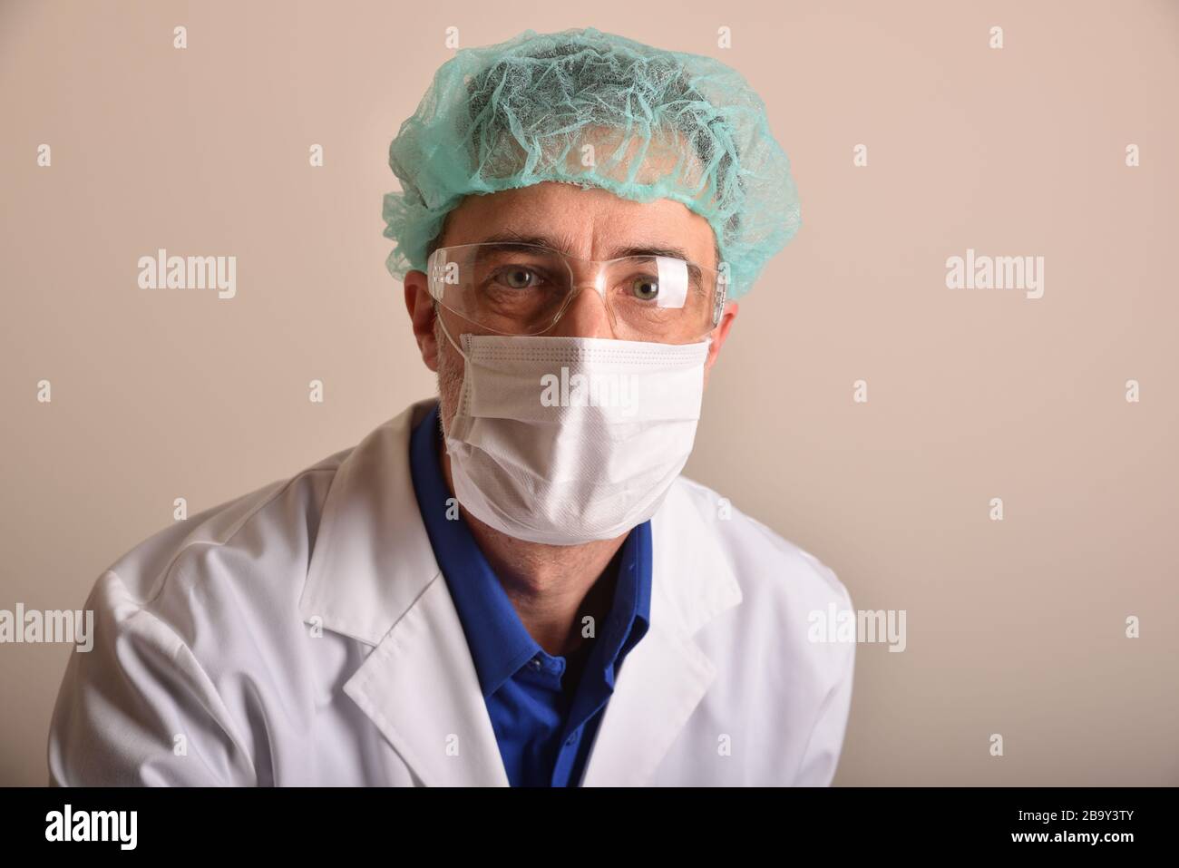 Doctor in his forties with face protection such as a mask, glasses and ...