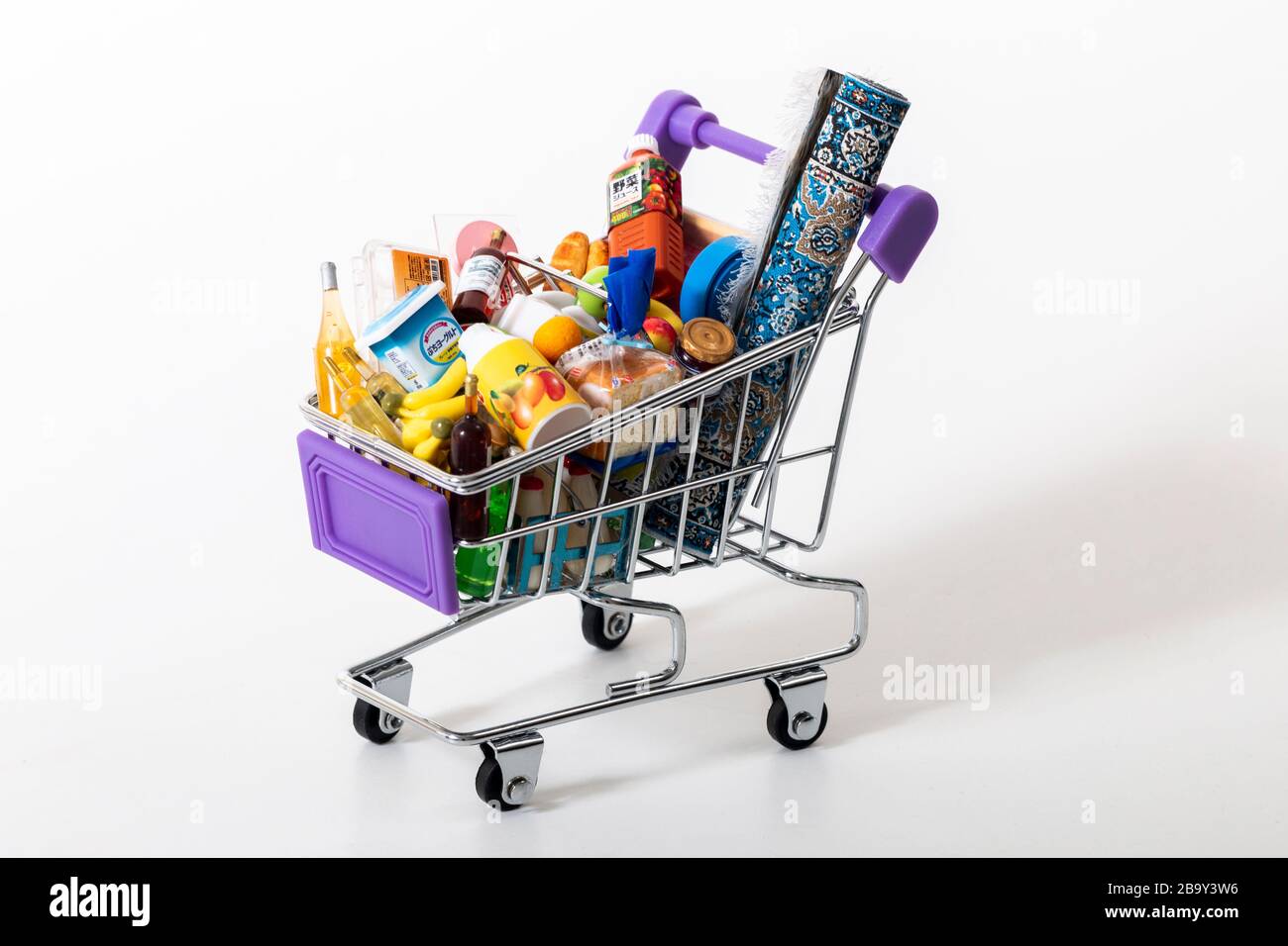 Miniature shopping cart full with goods isolated on white background ...
