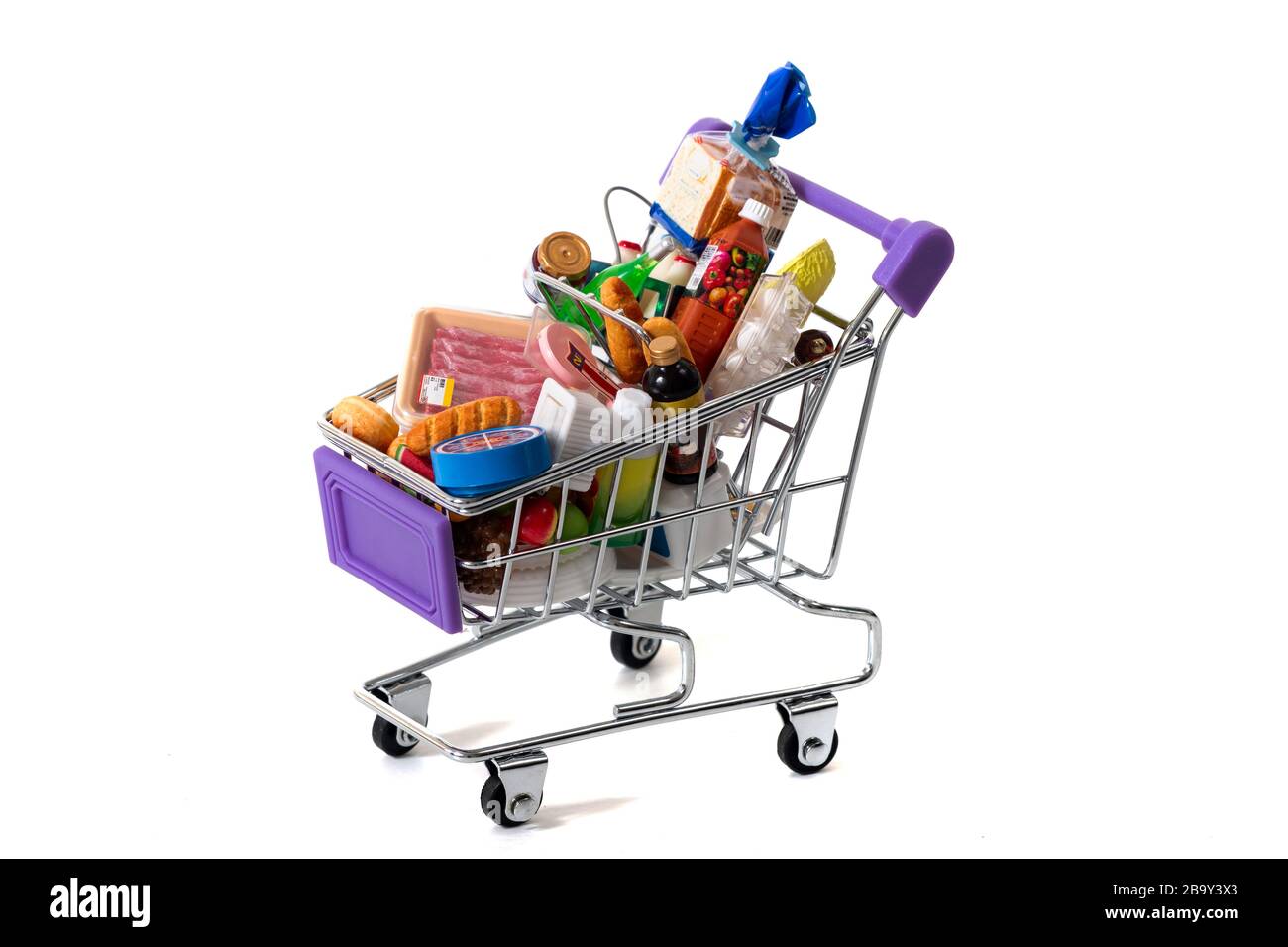 Miniature shopping cart full with goods isolated on white background ...