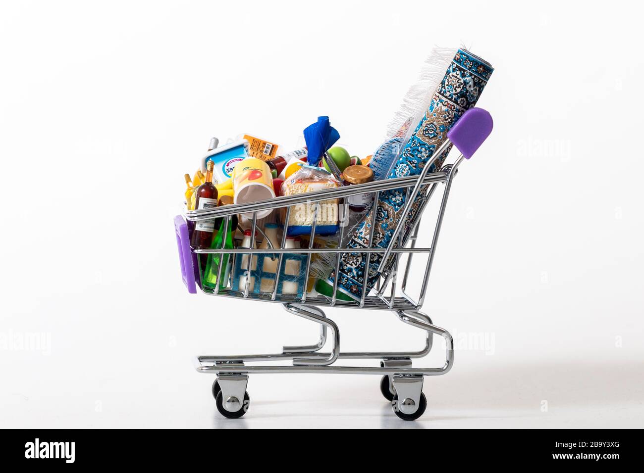 Miniature shopping cart full with goods isolated on white background ...