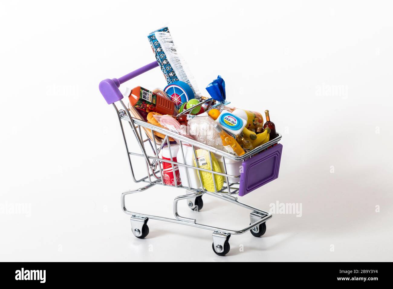 Miniature shopping cart full with goods isolated on white background ...