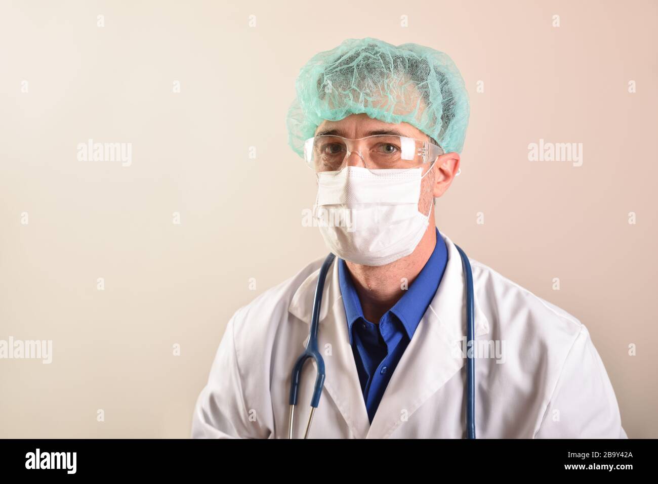 Doctor in his forties with face protection such as a mask, glasses and ...