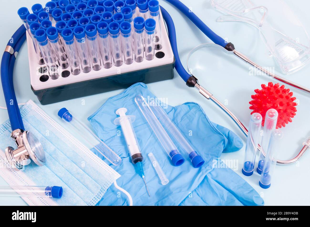 Several laboratory objects including protective mask, gloves, vial rack ...