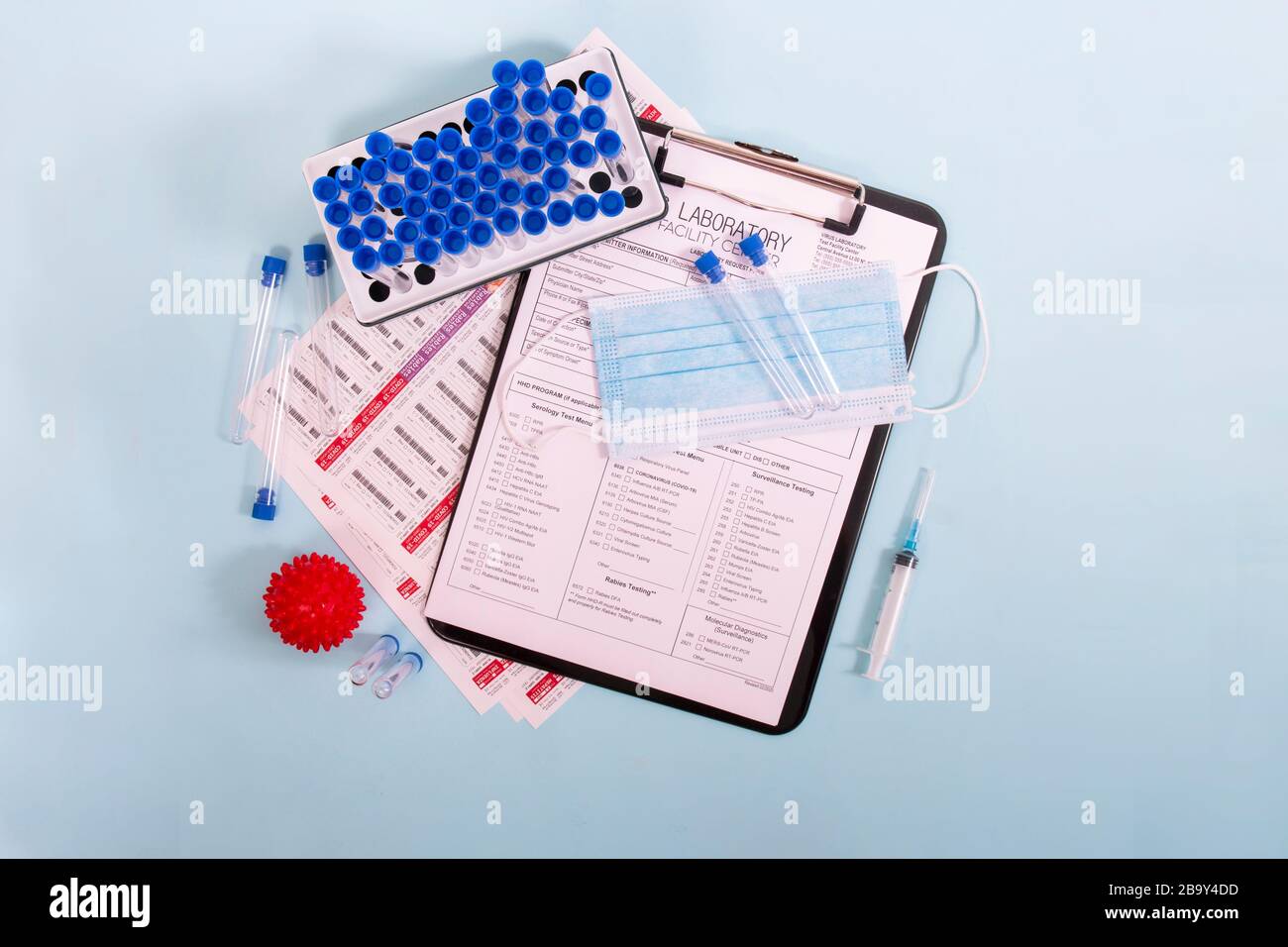 Several laboratory objects including protective mask, vial rack with ...