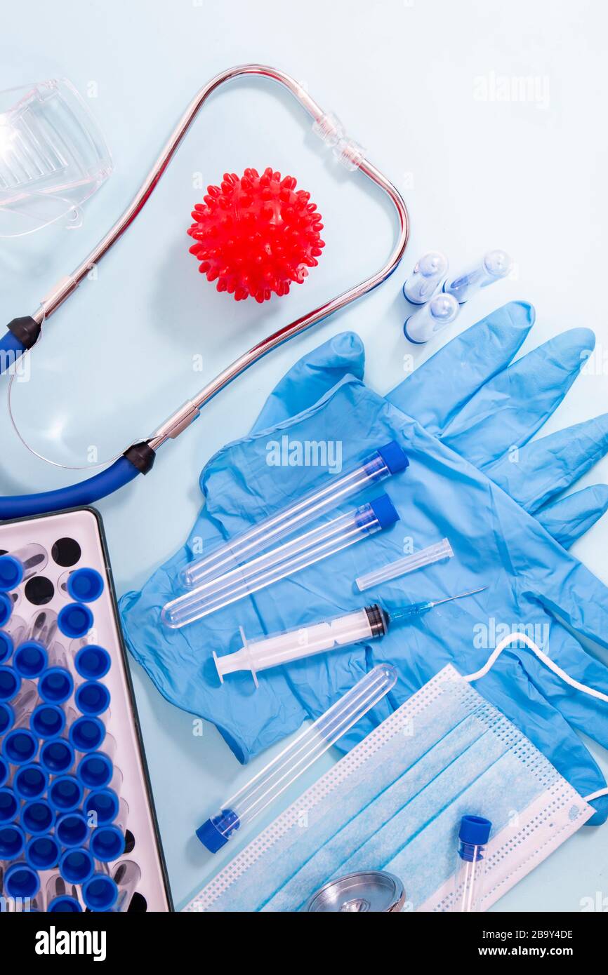 Several laboratory objects including protective mask, gloves, vial rack ...