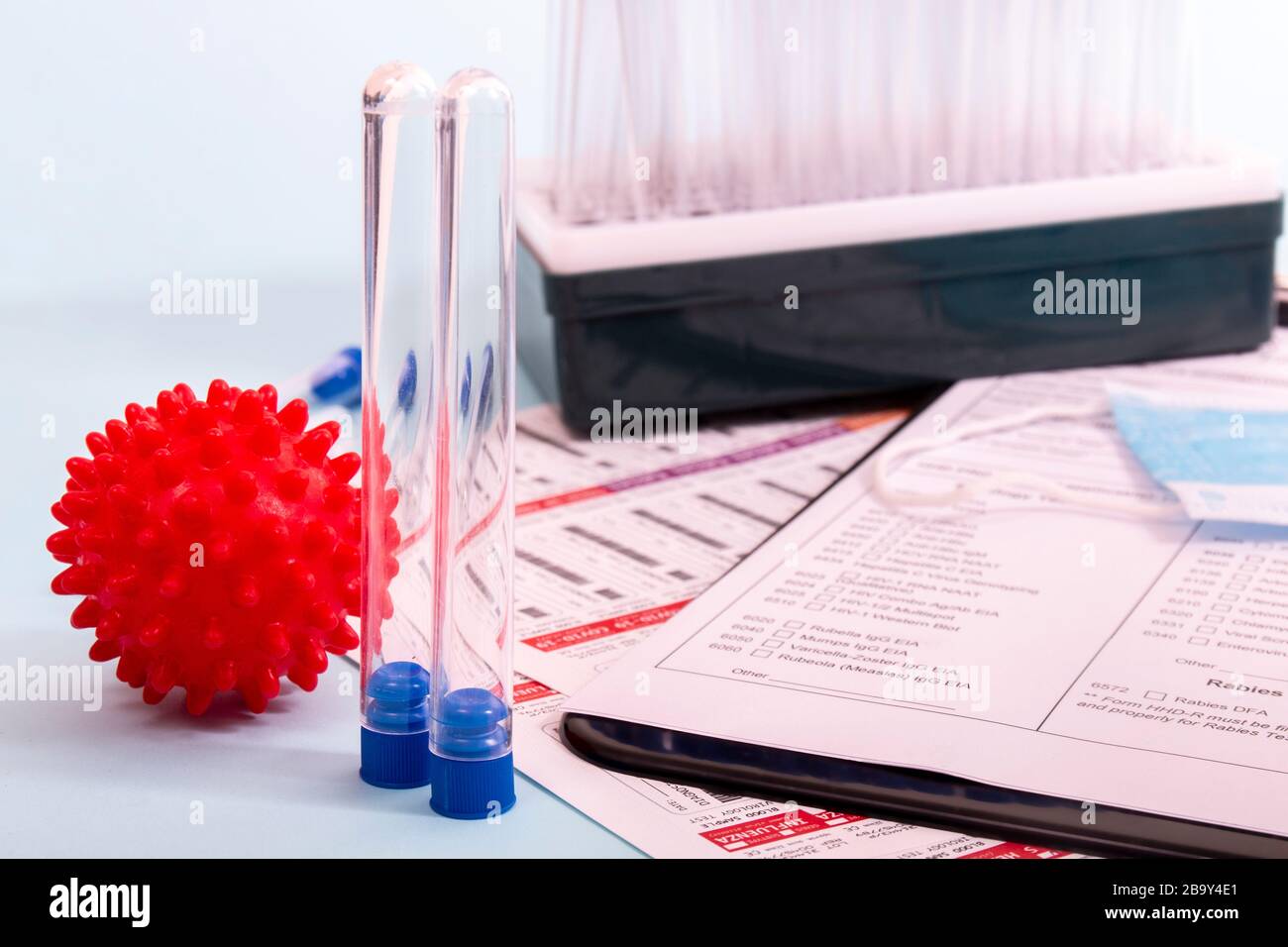 Several laboratory objects including protective mask, vial rack with ...