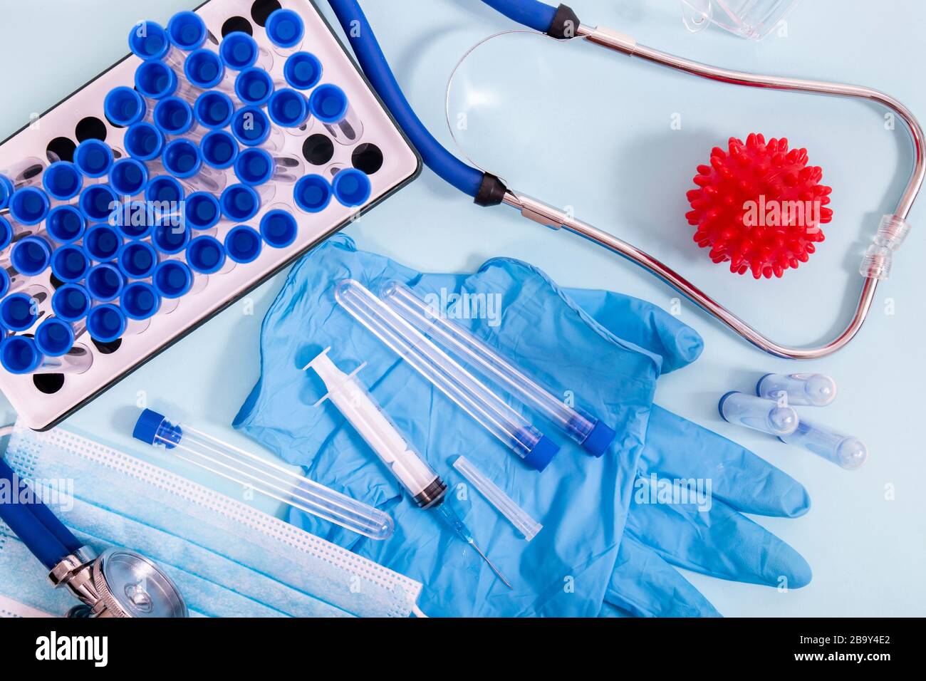 Several laboratory objects including protective mask, gloves, vial rack ...