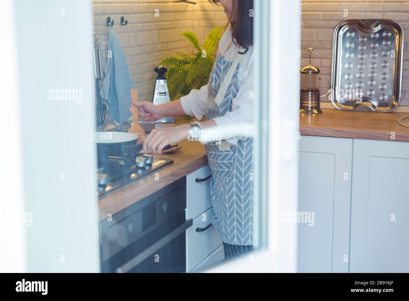 woman cooking pancakes view through window Stock Photo - Alamy