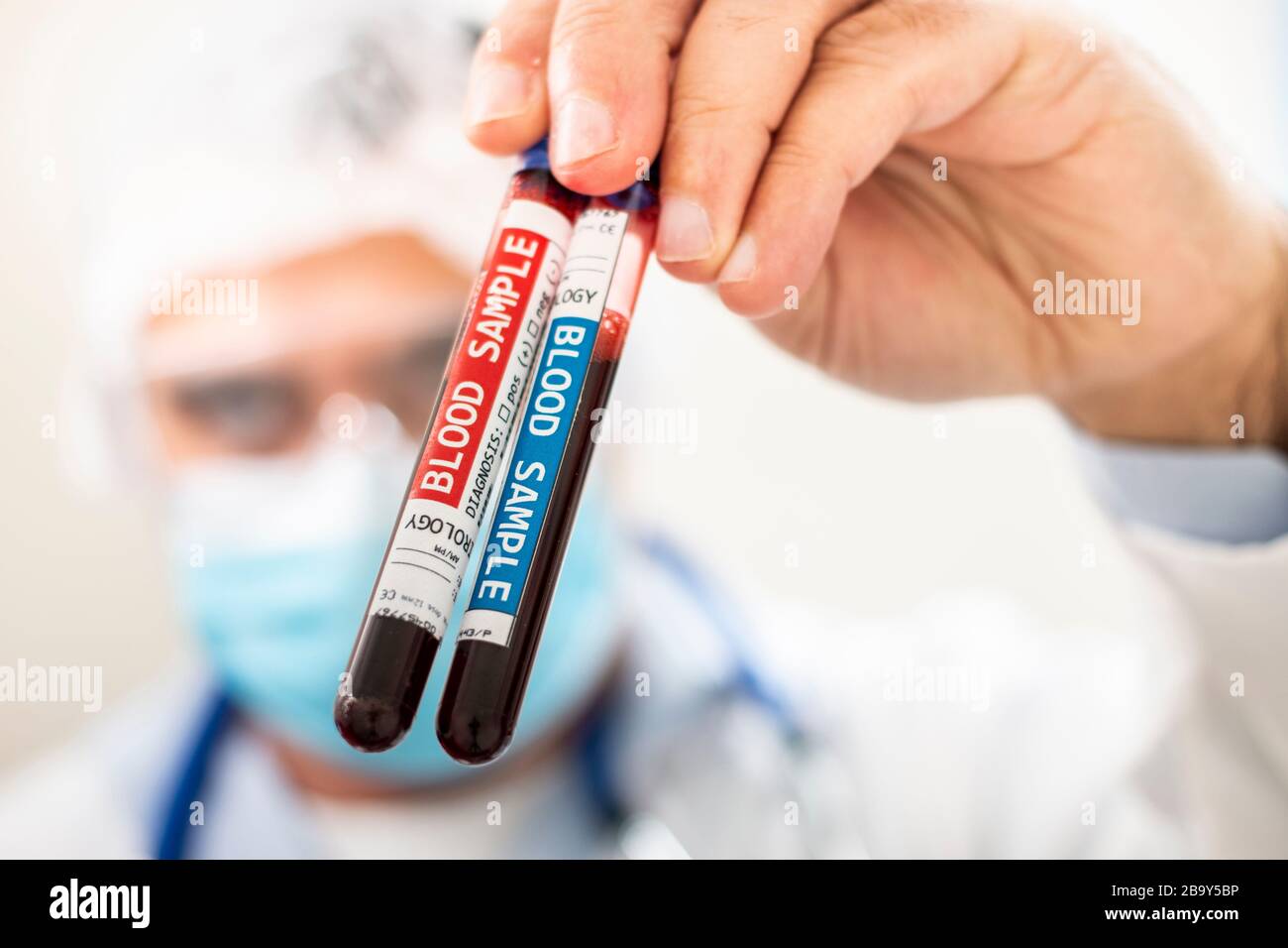 View of a doctor holding a fictional test tube blood sample, infected ...