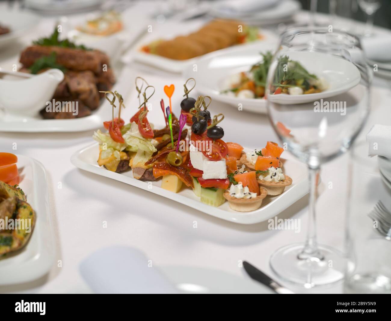 Set of canapes of fish, vegetables, meat on a plate on a white ...