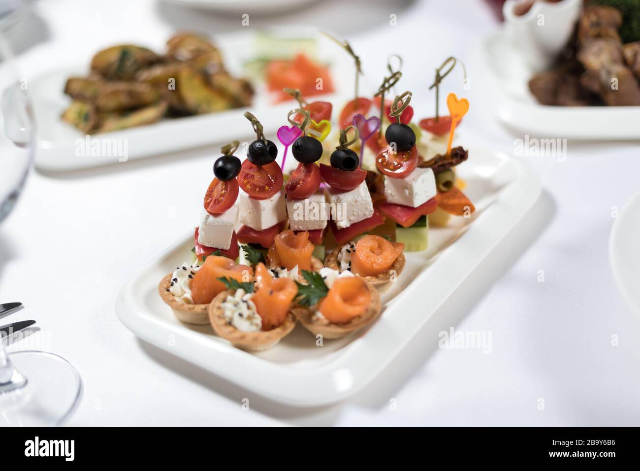 Set of canapes of fish, vegetables, meat on a plate on a white ...