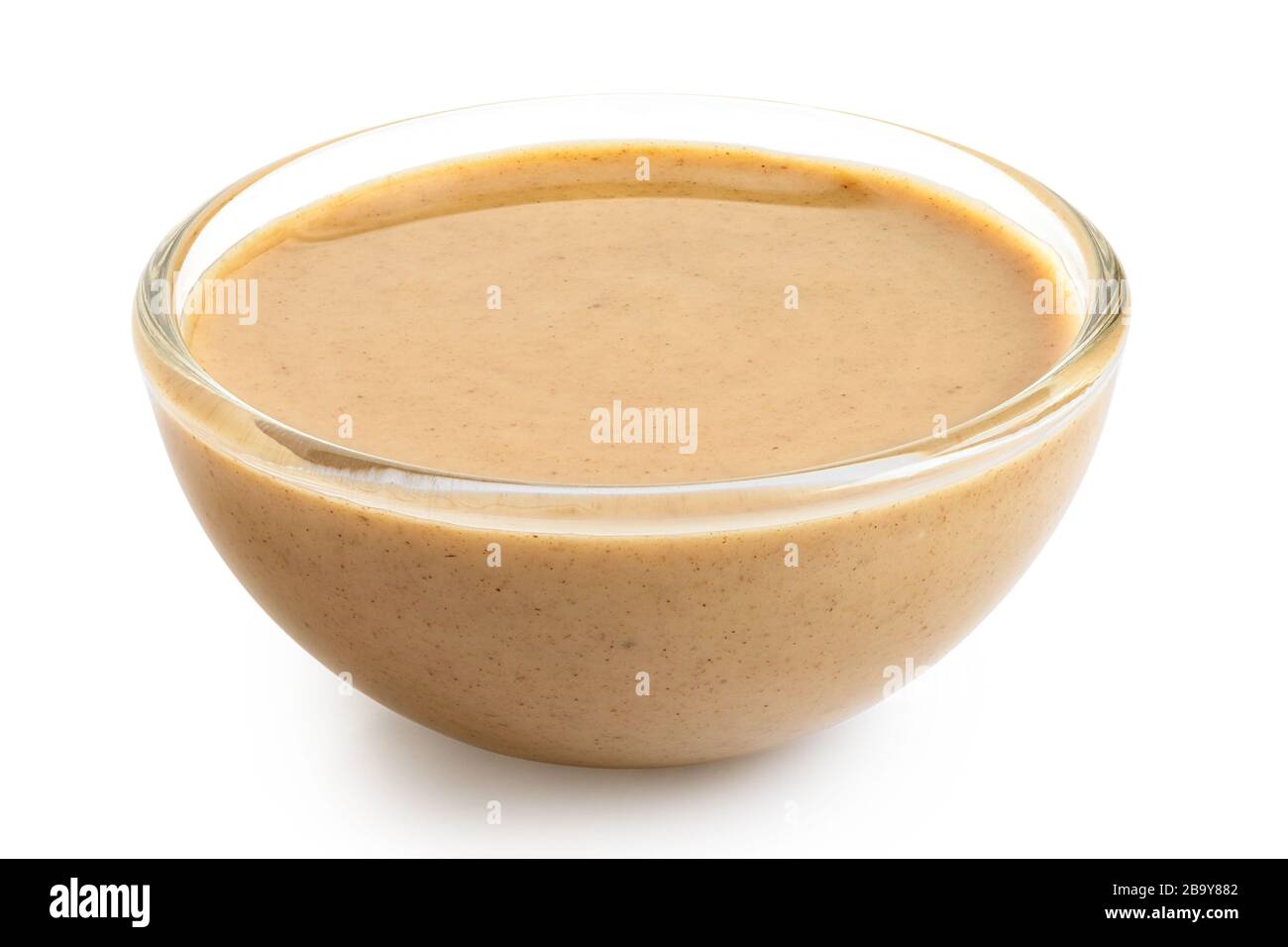 Tahini in a glass bowl isolated on white Stock Photo - Alamy