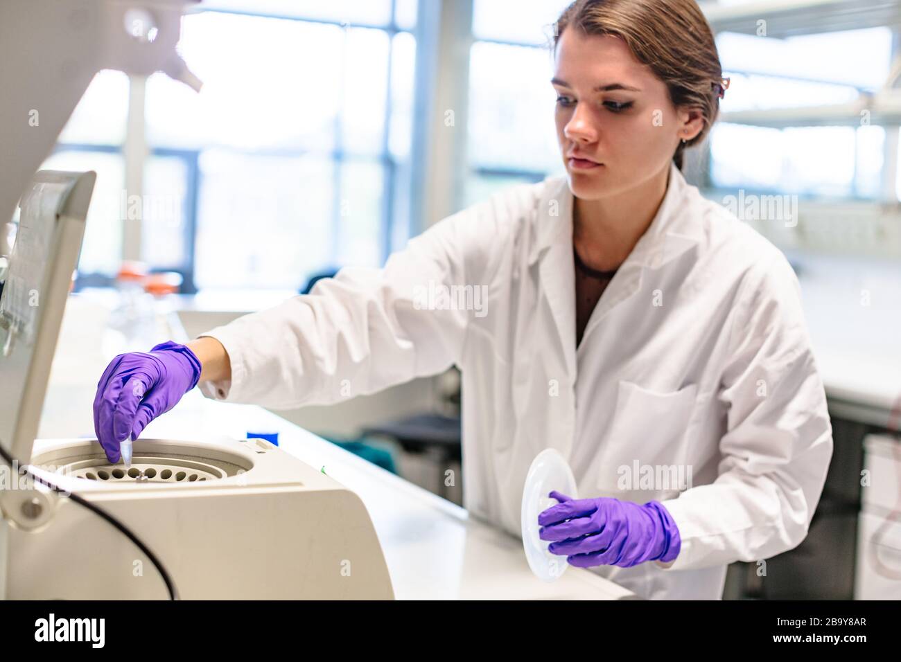 Female research scientist loading centrifuge hi-res stock photography ...