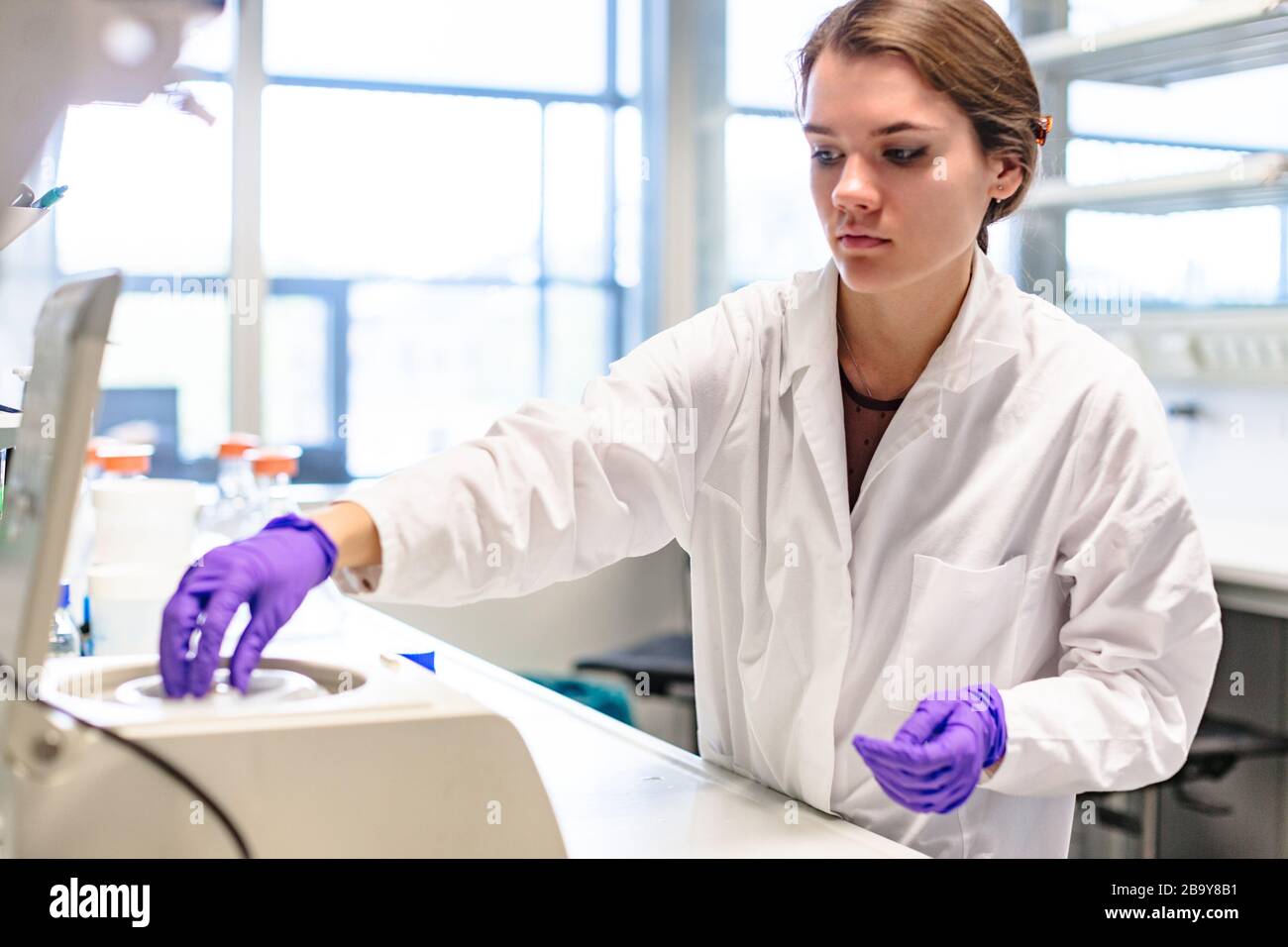 Female researcher loading samples in centrifuge in laboratory Stock ...