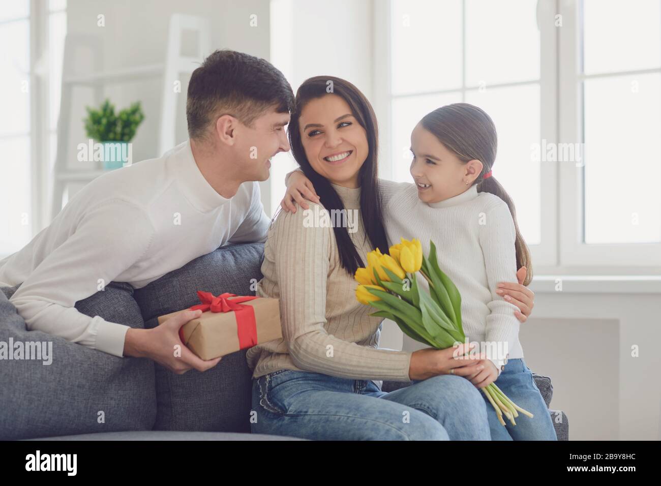 Happy mother's day. Father and baby daughter congratulates mom with ...