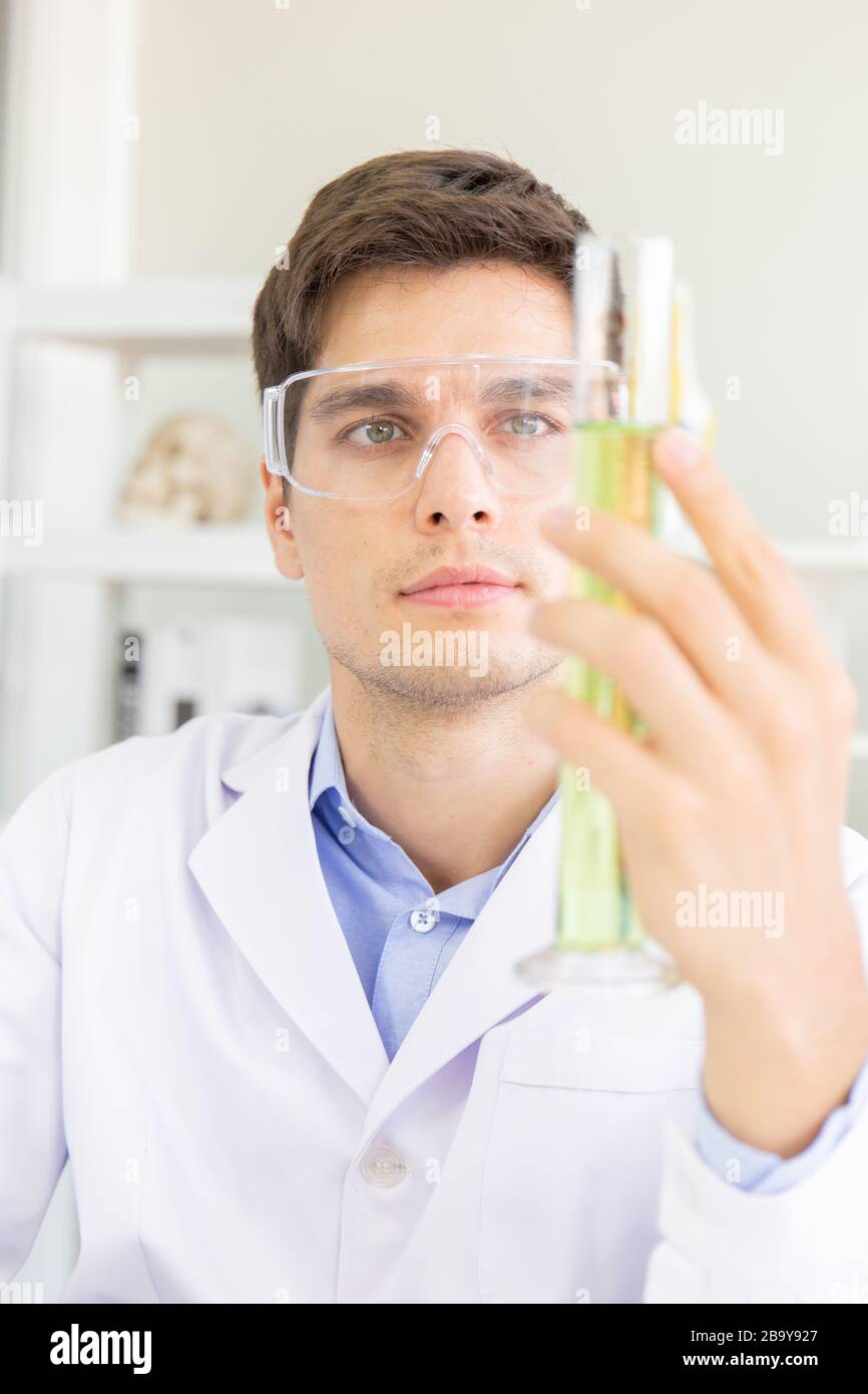 A male scientist working in a science lab with various equipment in the ...