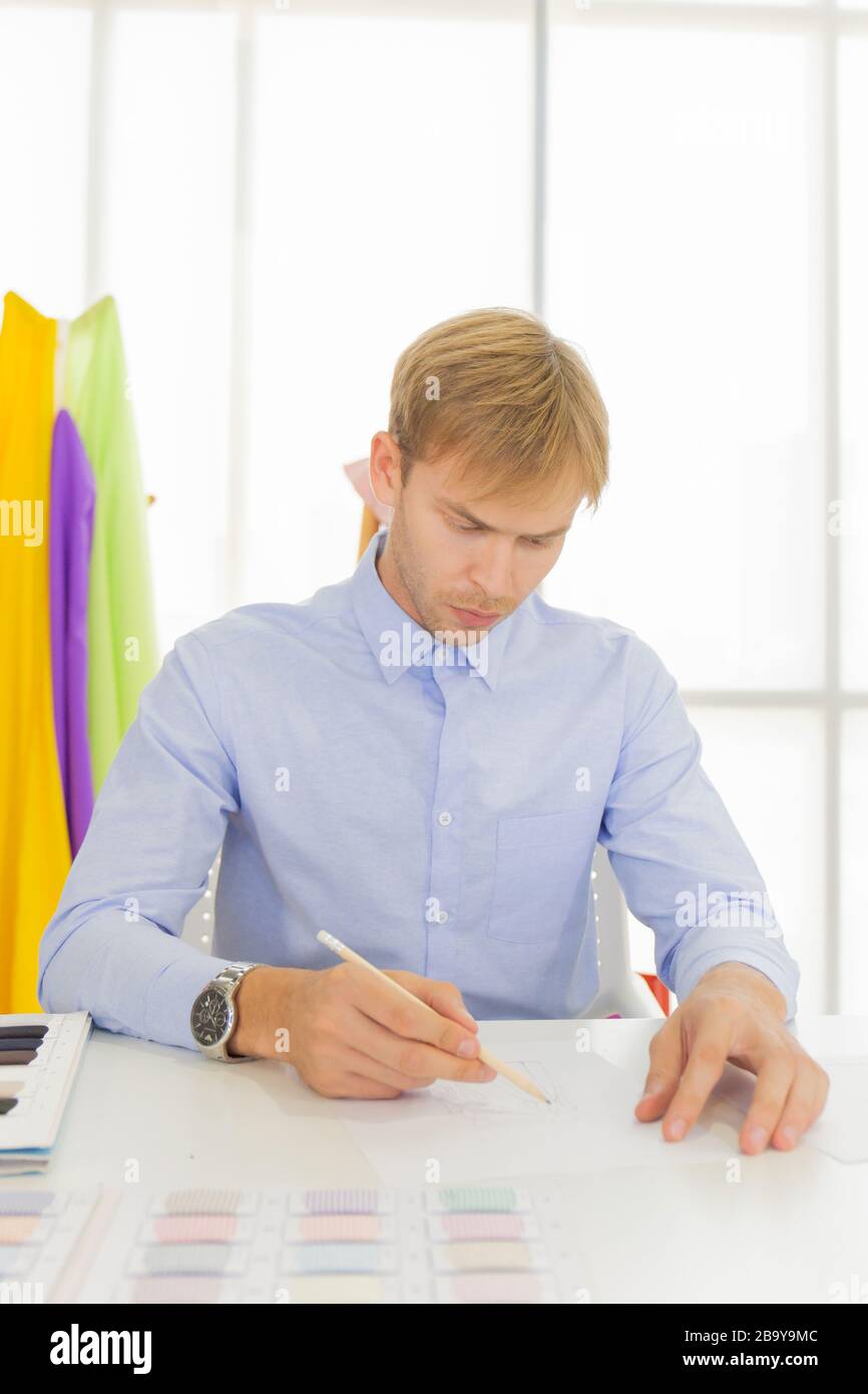 Male designers who are sketching on paper to design clothes Stock Photo ...