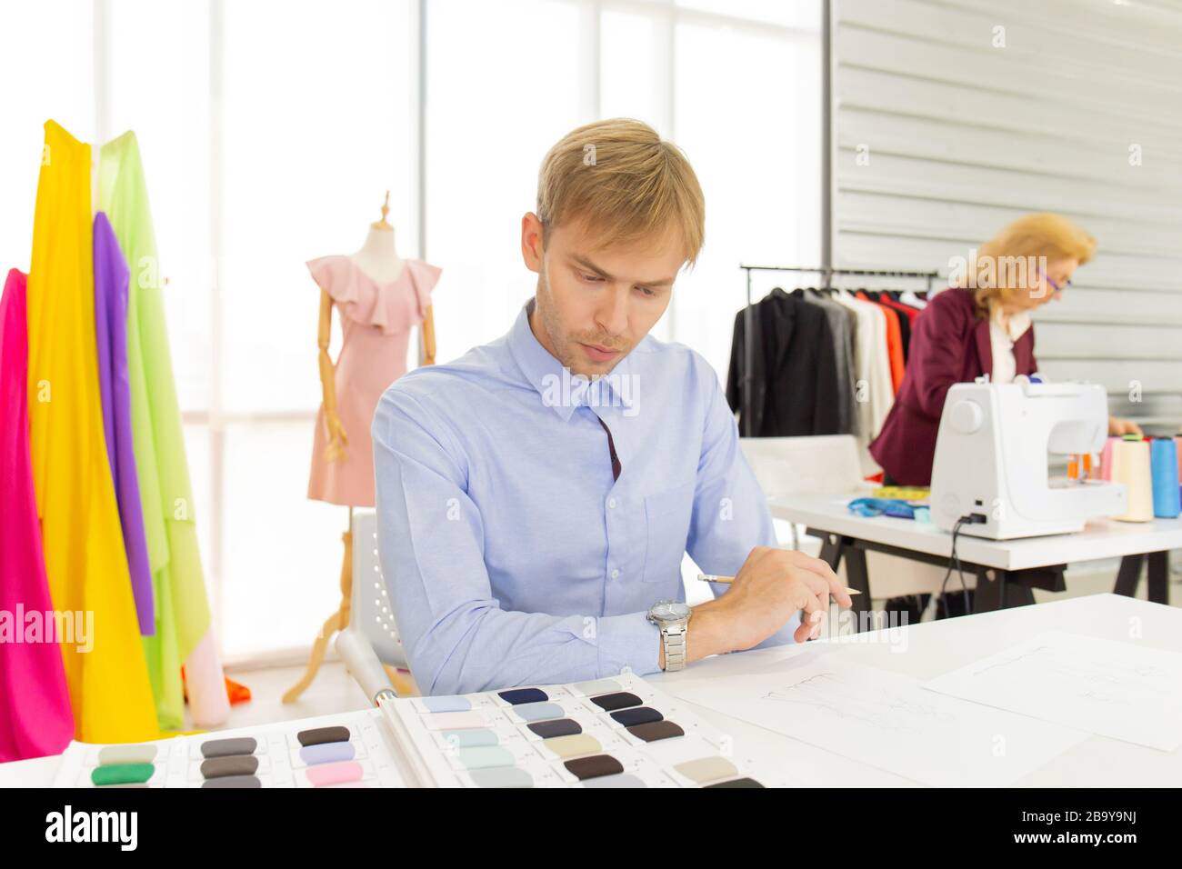 Male designers who are sketching on paper to design clothes Stock Photo ...