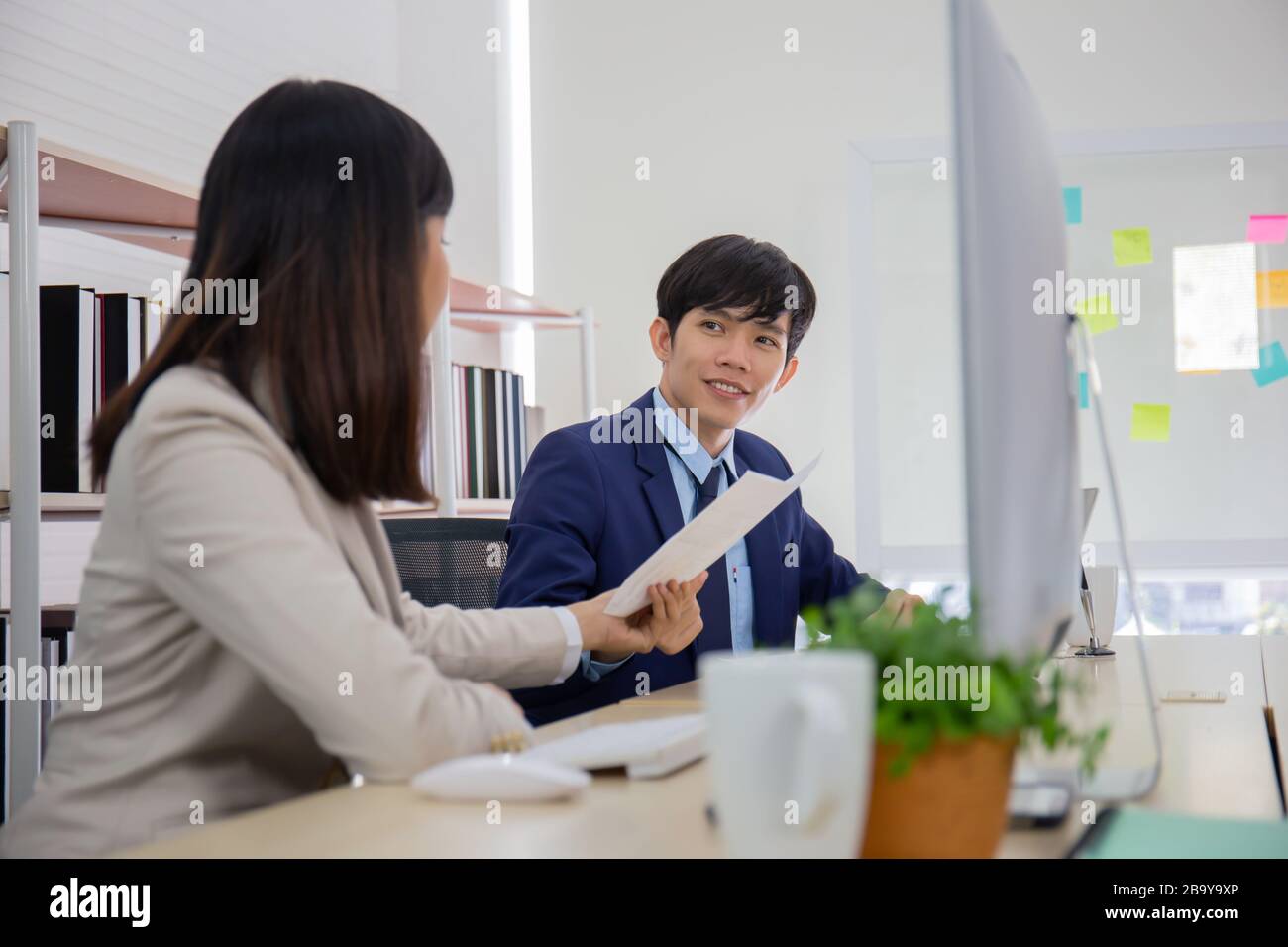 Asian female colleague hand over documents to businessmen on the desk ...