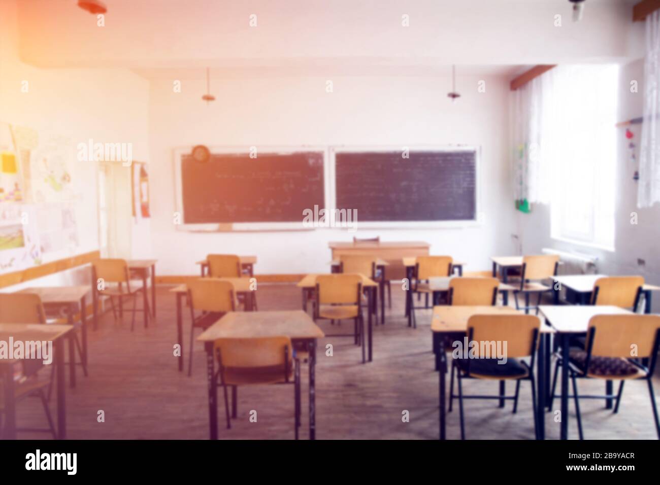 Back to school concept. Blurred view of sunny classroom with chairs ...