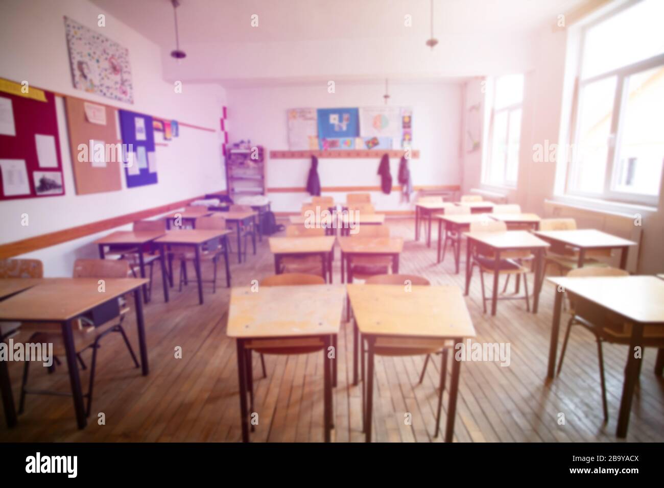 Back to school concept. Blurred view of sunny classroom with chairs ...