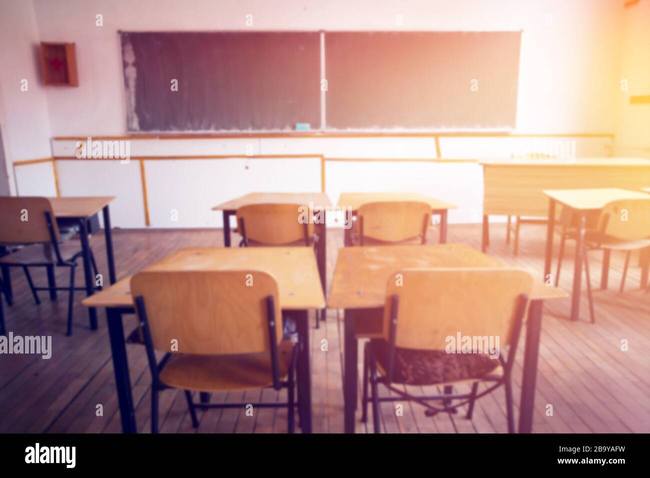 Back to school concept. Blurred view of sunny classroom with chairs ...