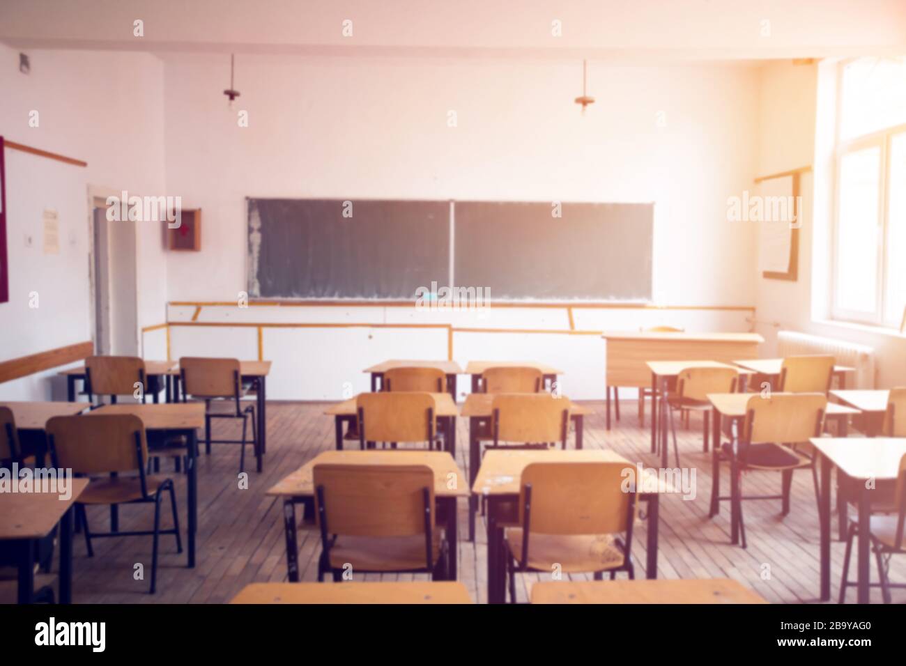Back to school concept. Blurred view of sunny classroom with chairs ...
