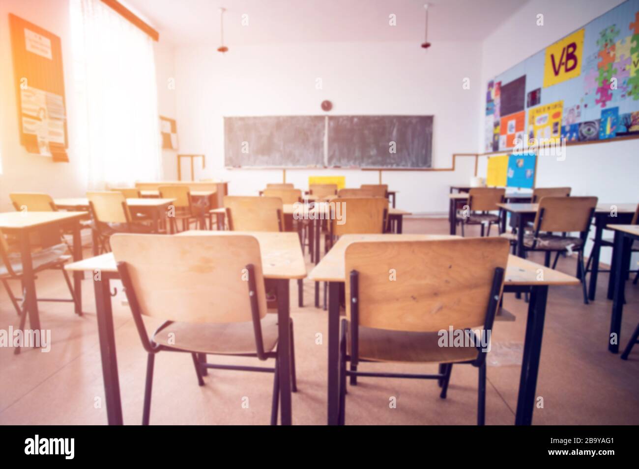 Back to school concept. Blurred view of sunny classroom with chairs ...
