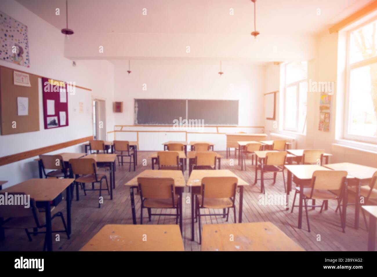 Back to school concept. Blurred view of sunny classroom with chairs ...
