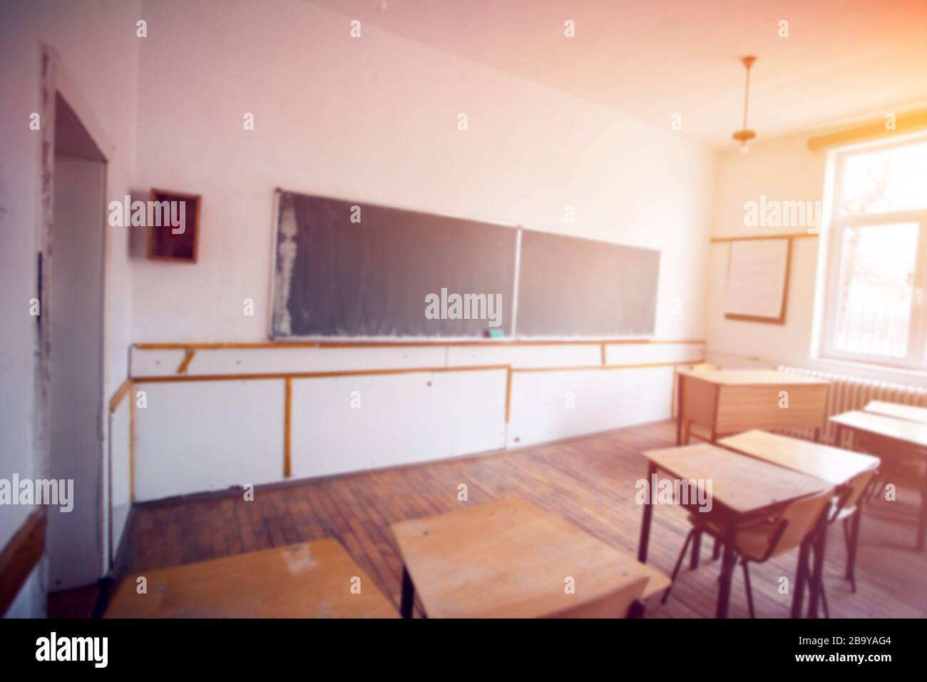 Back to school concept. Blurred view of sunny classroom with chairs ...