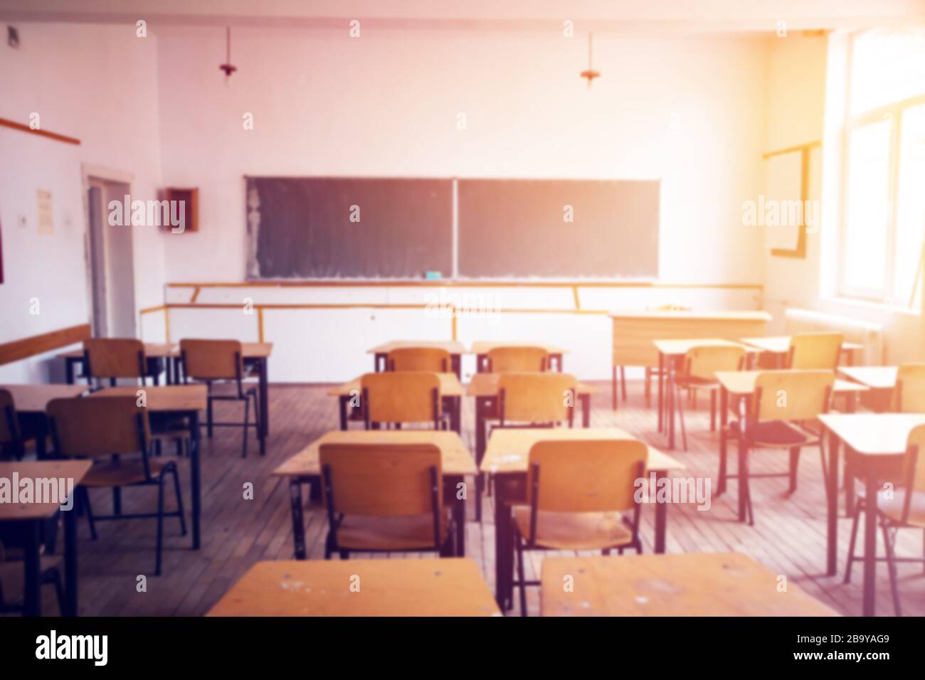 Back to school concept. Blurred view of sunny classroom with chairs ...