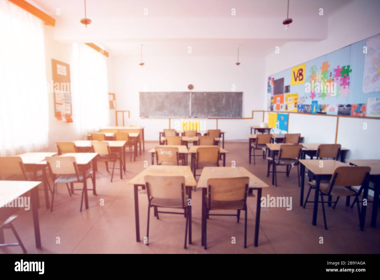 Back to school concept. Blurred view of sunny classroom with chairs ...